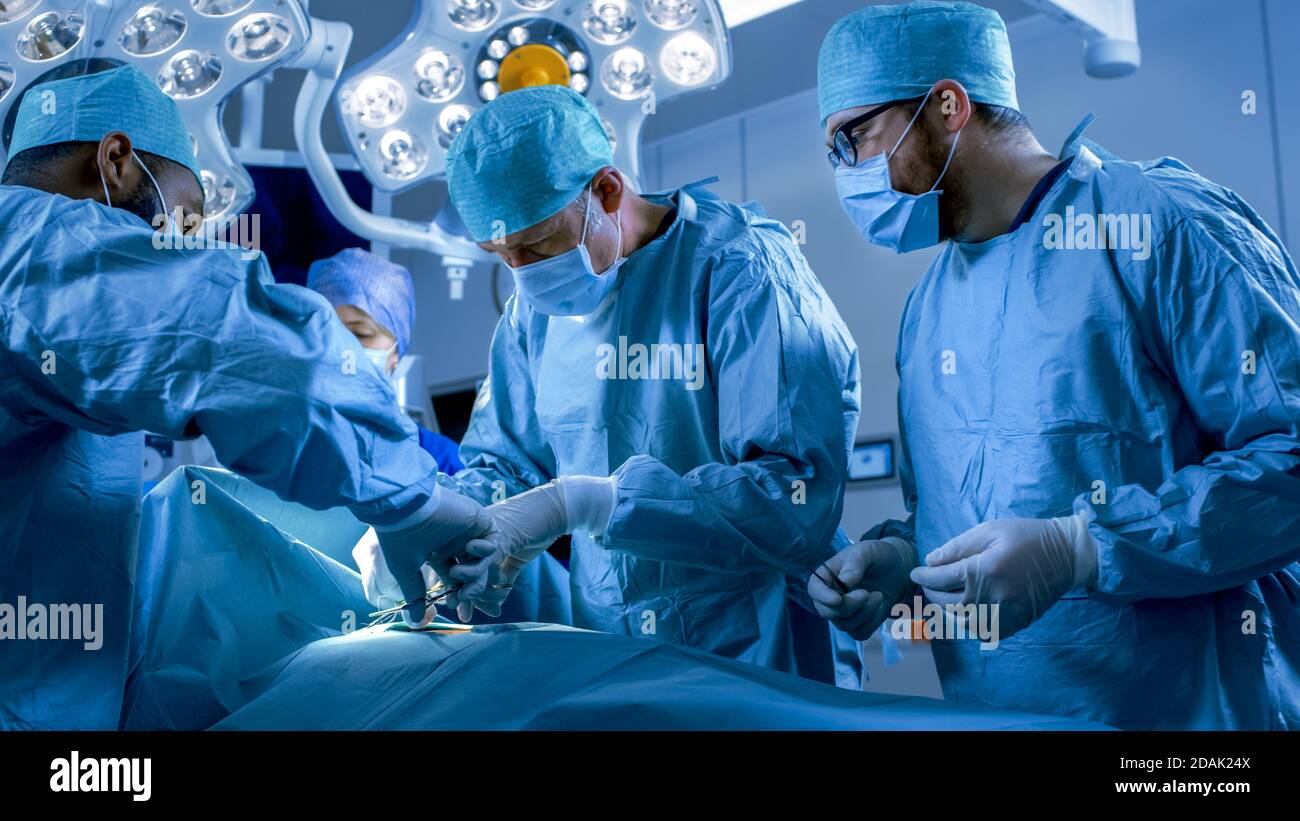 In the Hospital Operating Room Diverse Team of Professional Surgeons ...