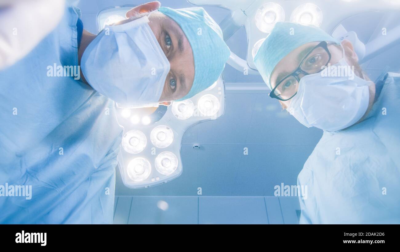 Low Angle Shot POV Patient View: Two Professional Surgeons Holding ...