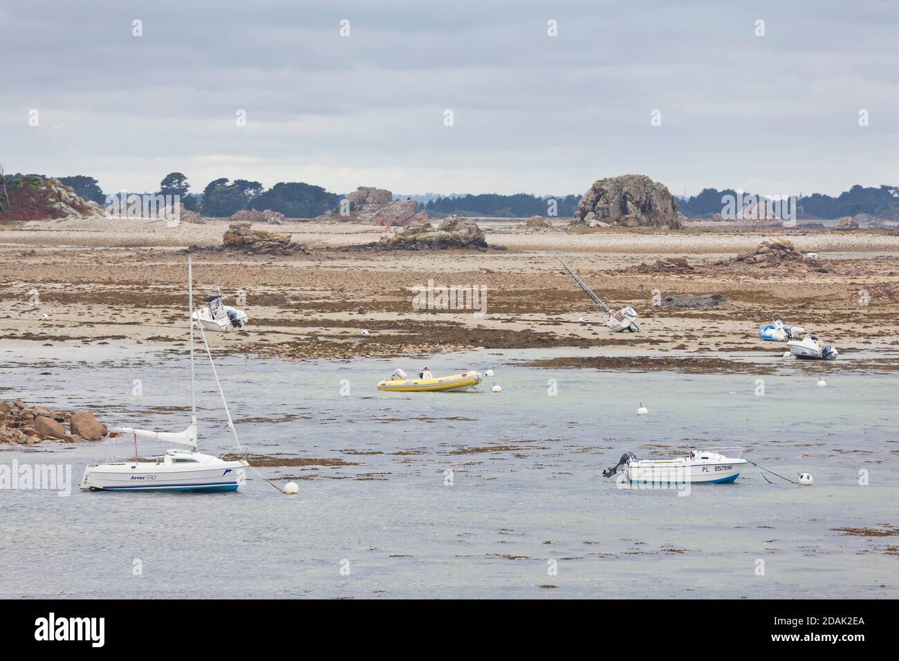Boats between rocks at Plougrescant Brittany Stock Photo - Alamy
