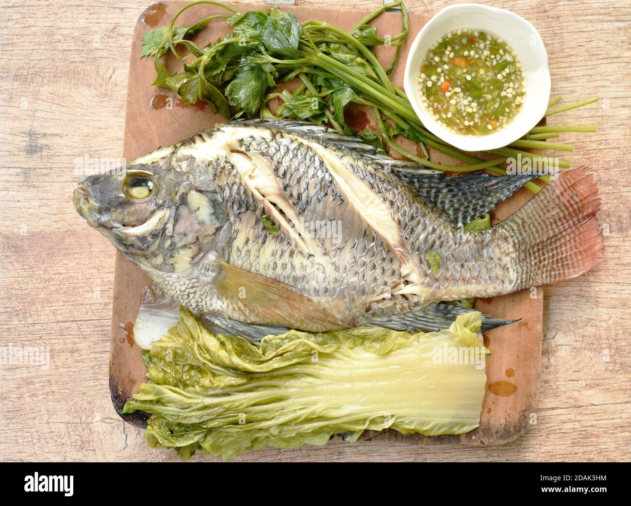 steamed mango fish with vegetable dipping spicy sauce on wooden chop ...