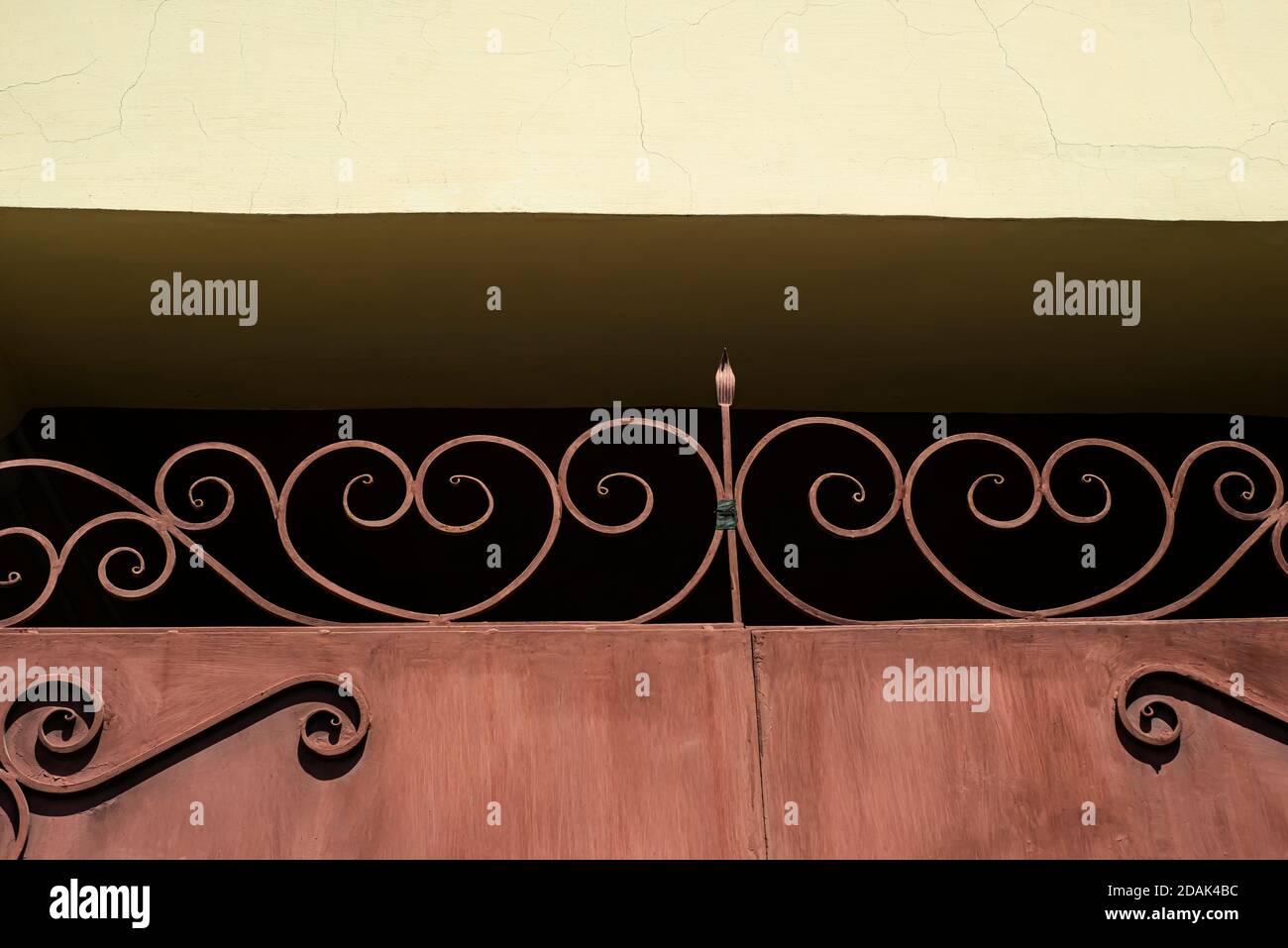 Old metal gates with forged monograms are painted with terracotta paint ...