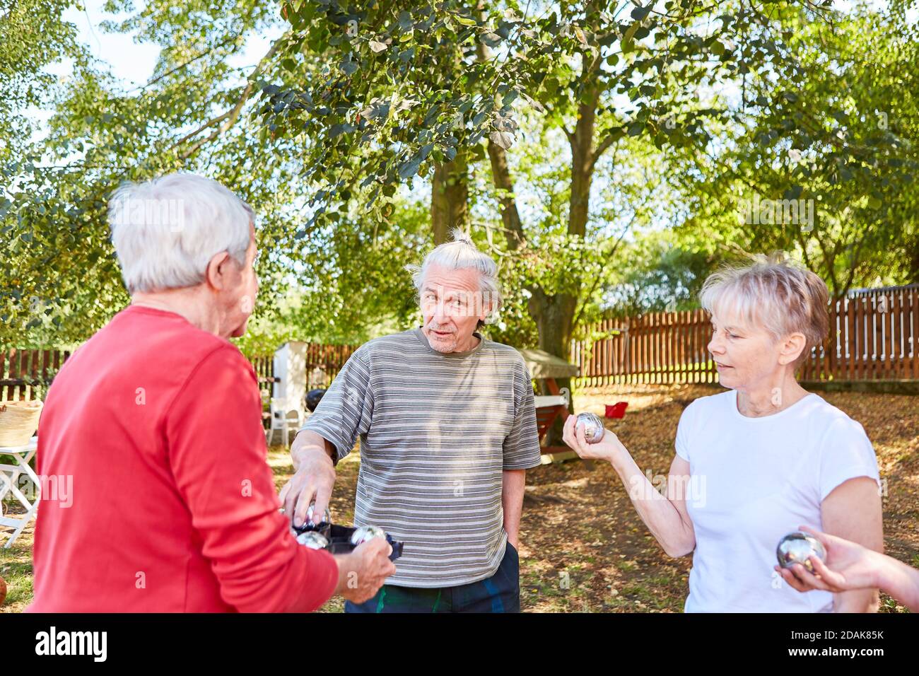 Group of seniors as a team playing boules together in the garden in ...