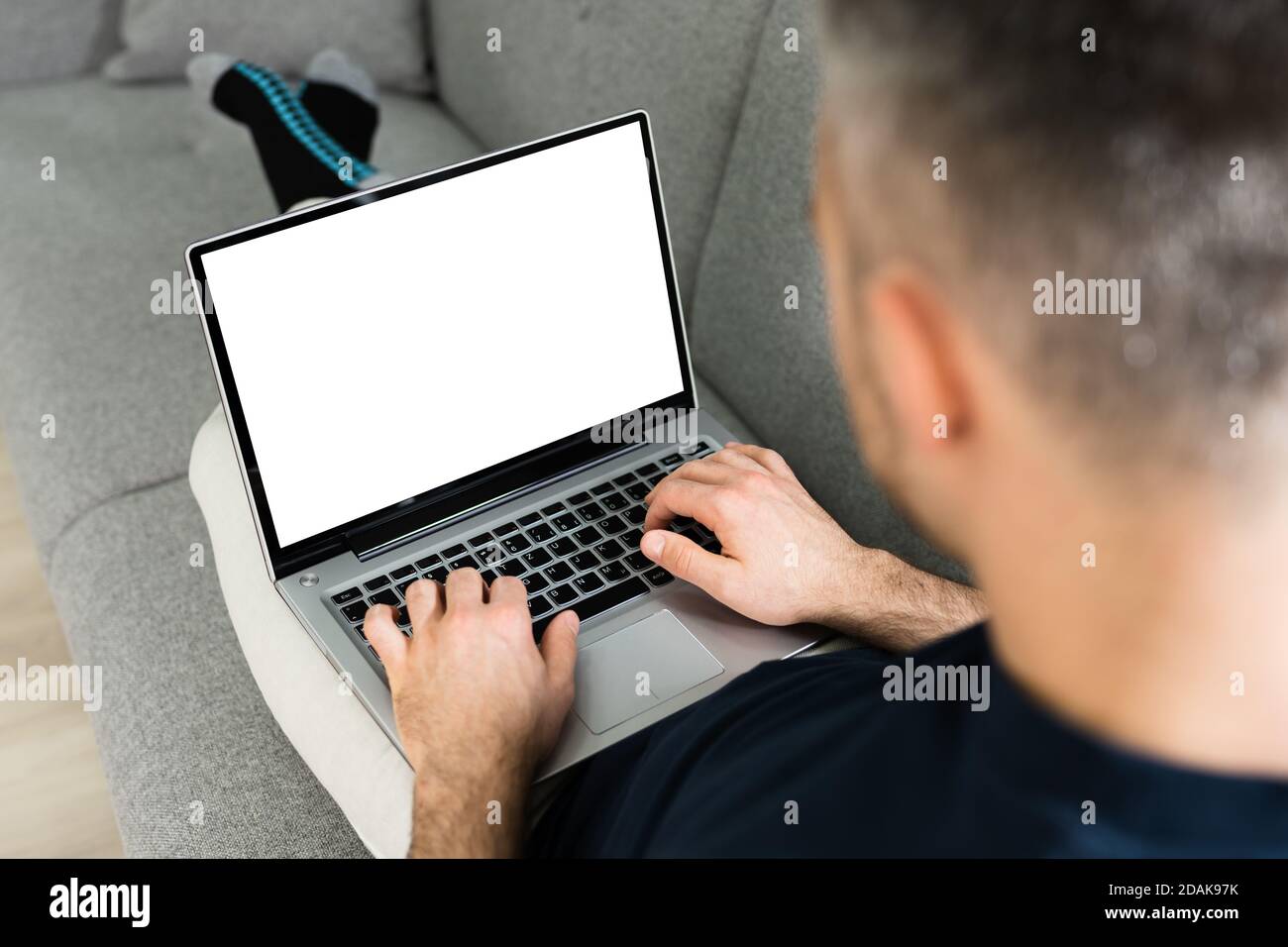 Guy Sitting On Sofa Using Laptop In Living Room Stock Photo - Alamy
