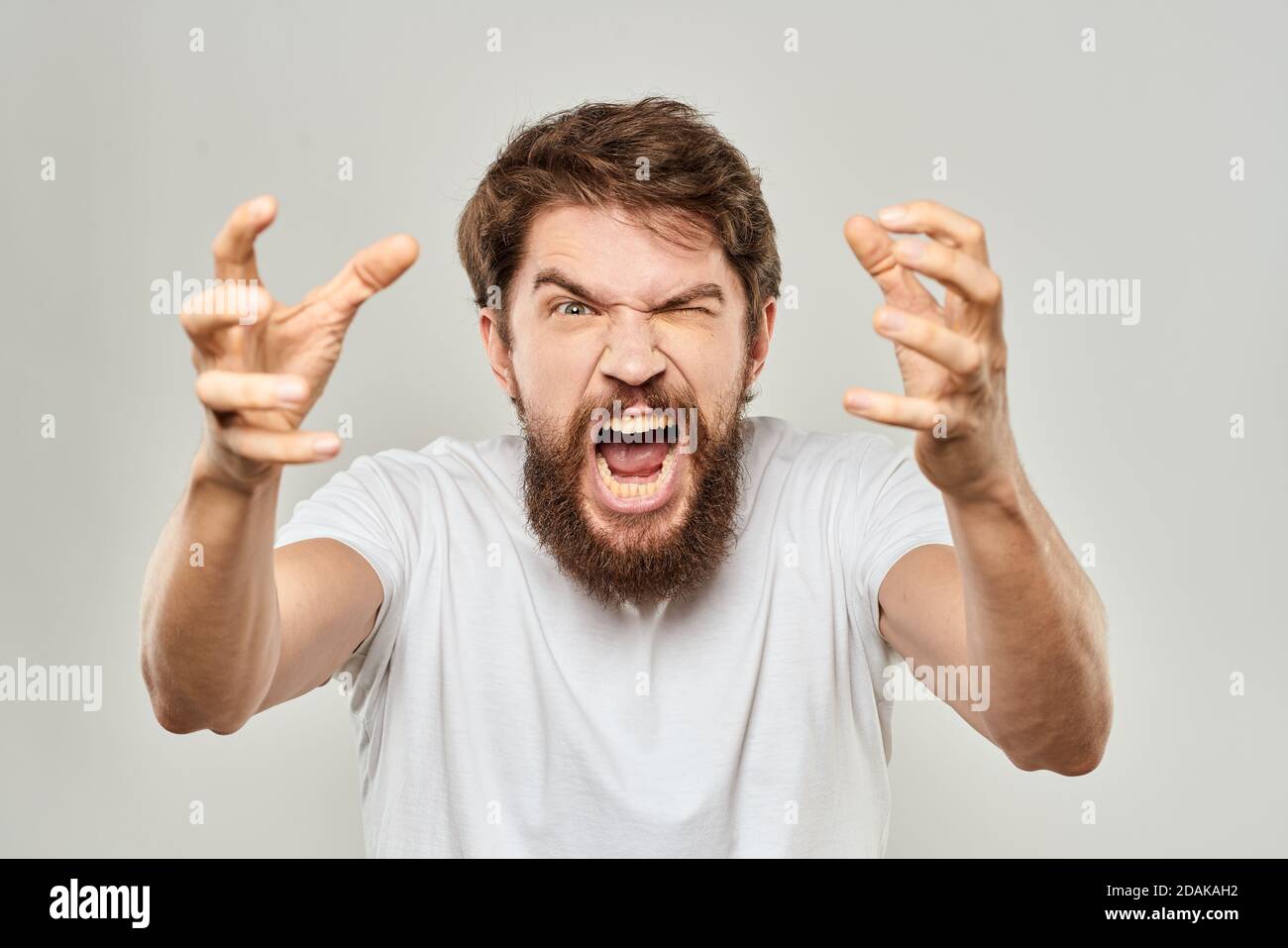 bearded man gesturing with his hands in a white t-shirt aggression ...