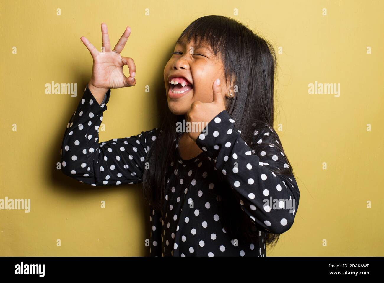 asian little girl showing a OK hand sign Stock Photo - Alamy