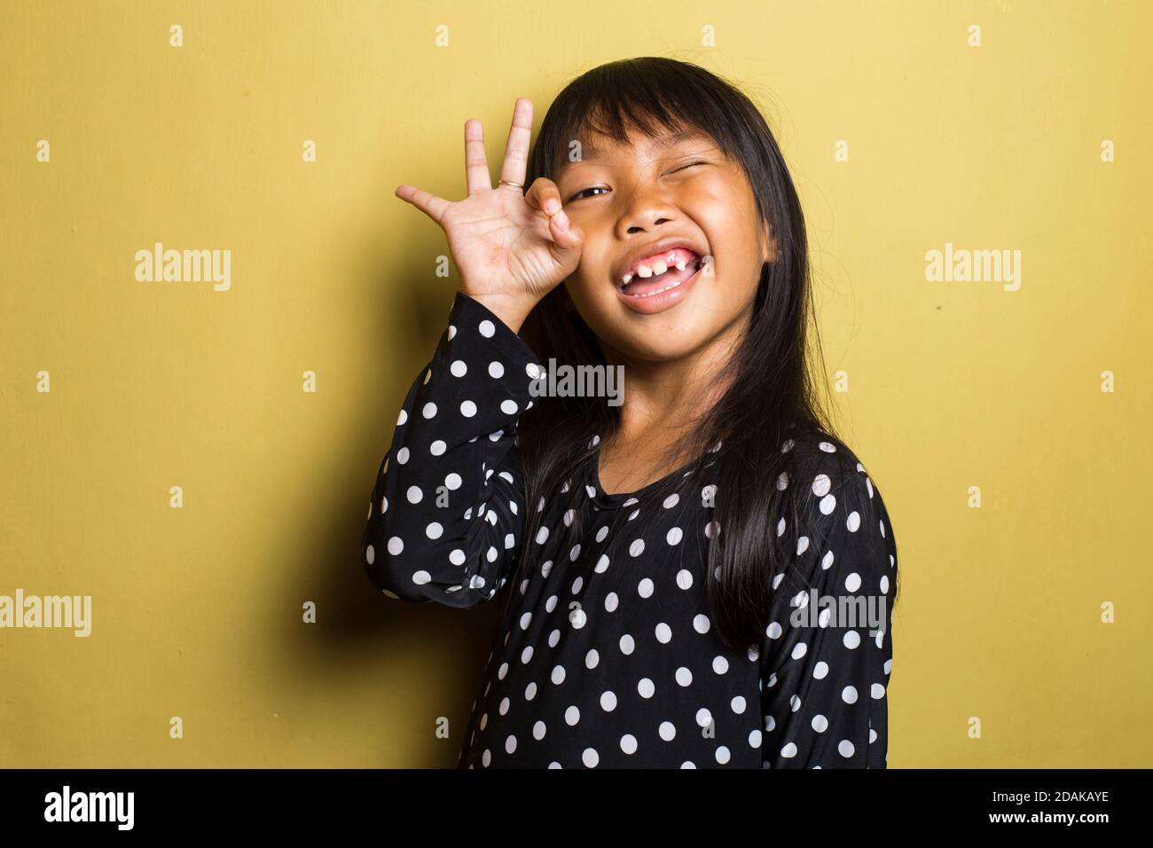 asian little girl showing a OK hand sign Stock Photo - Alamy