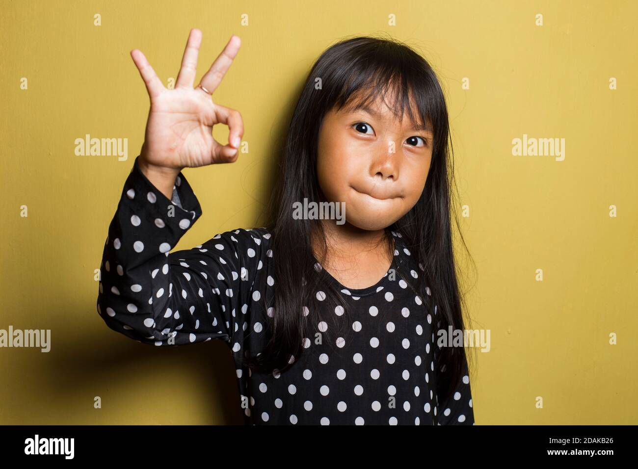 asian little girl showing a OK hand sign Stock Photo - Alamy