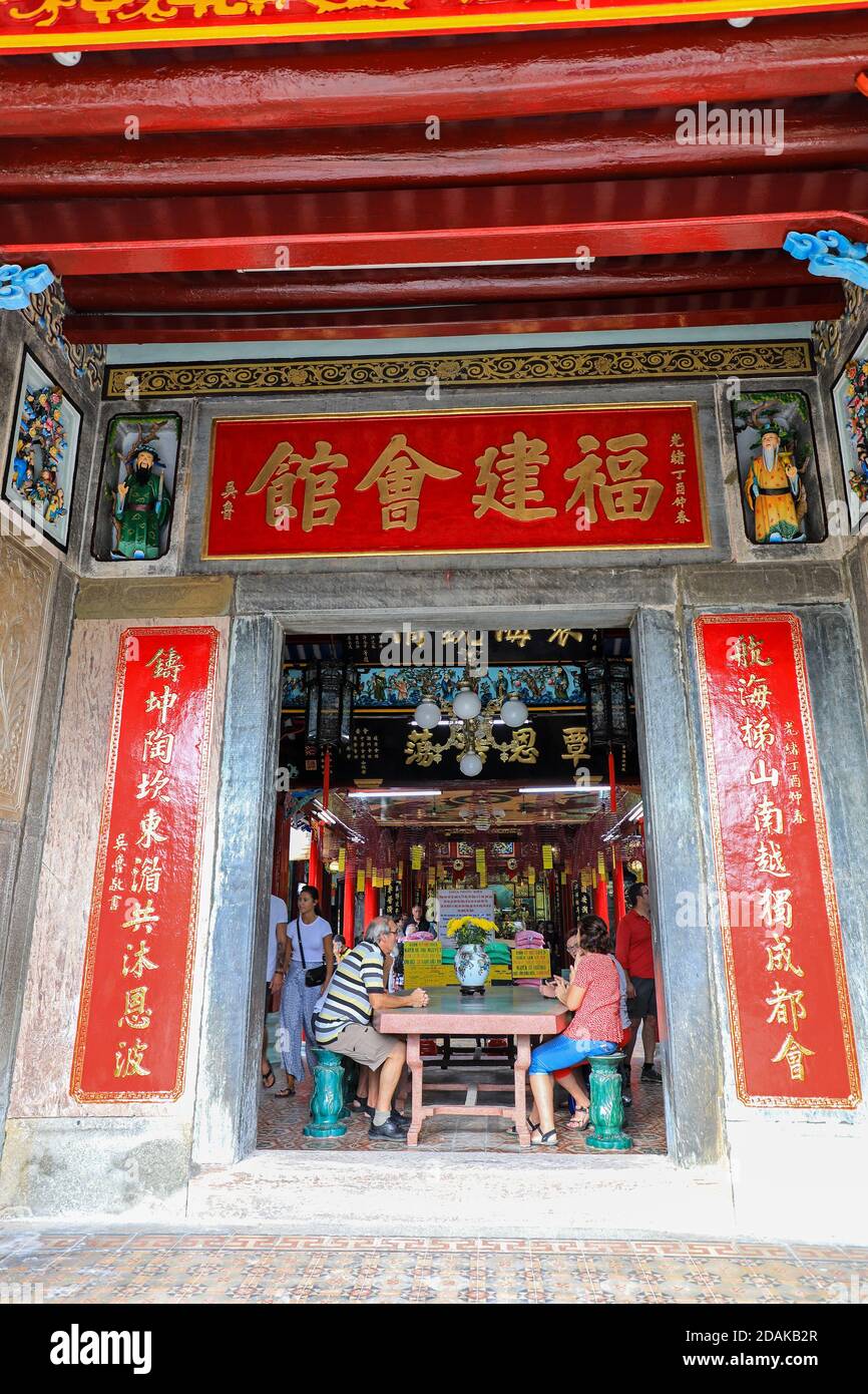 People sitting at a table inside the Chinese Assembly Hall, Hoi An ...