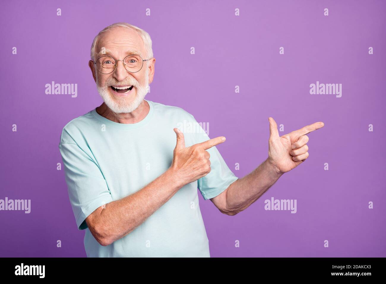 Photo portrait of smiling old man pointing two fingers to side isolated ...