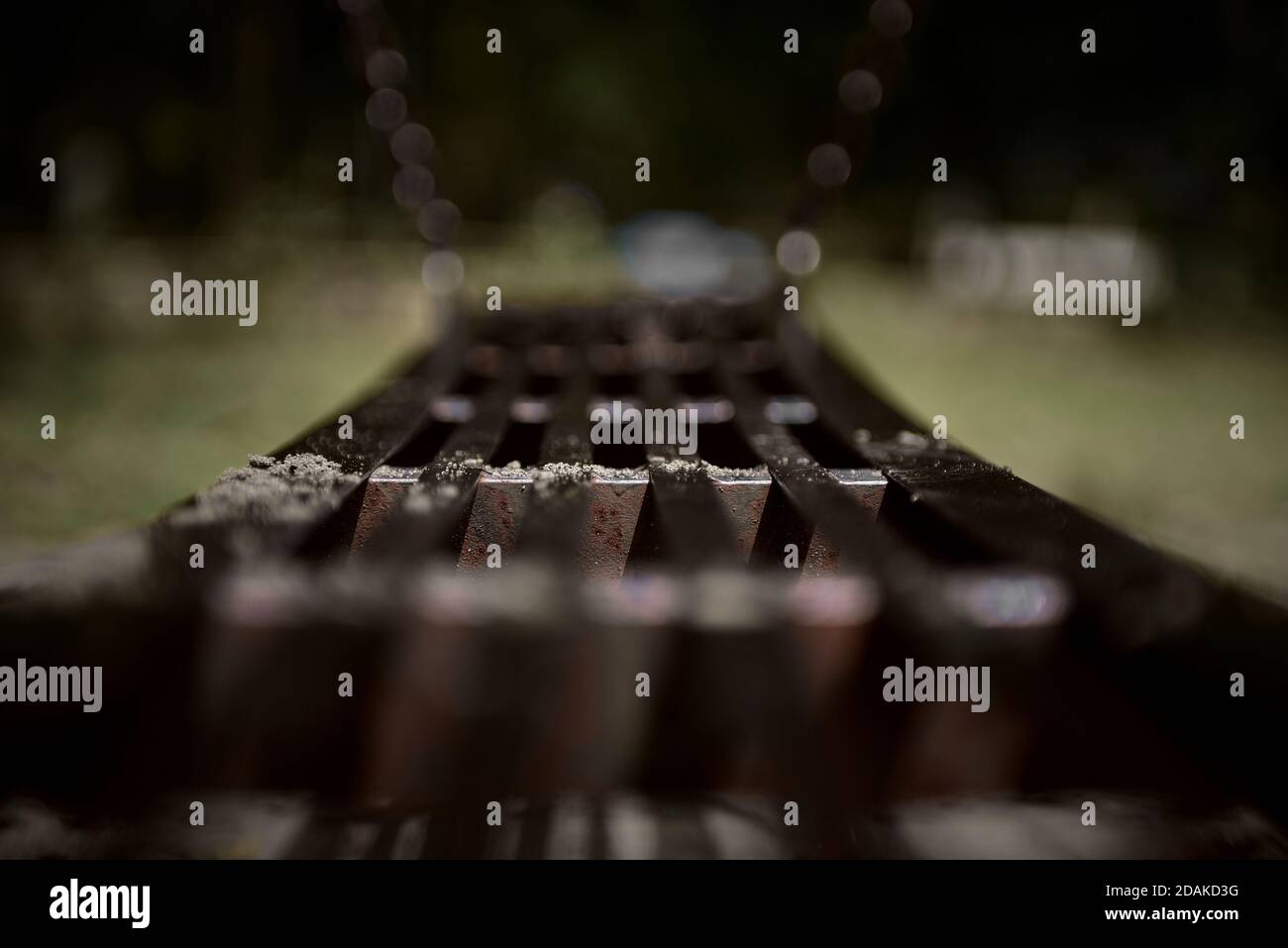 Side view of a black rusty metal park bench Stock Photo - Alamy