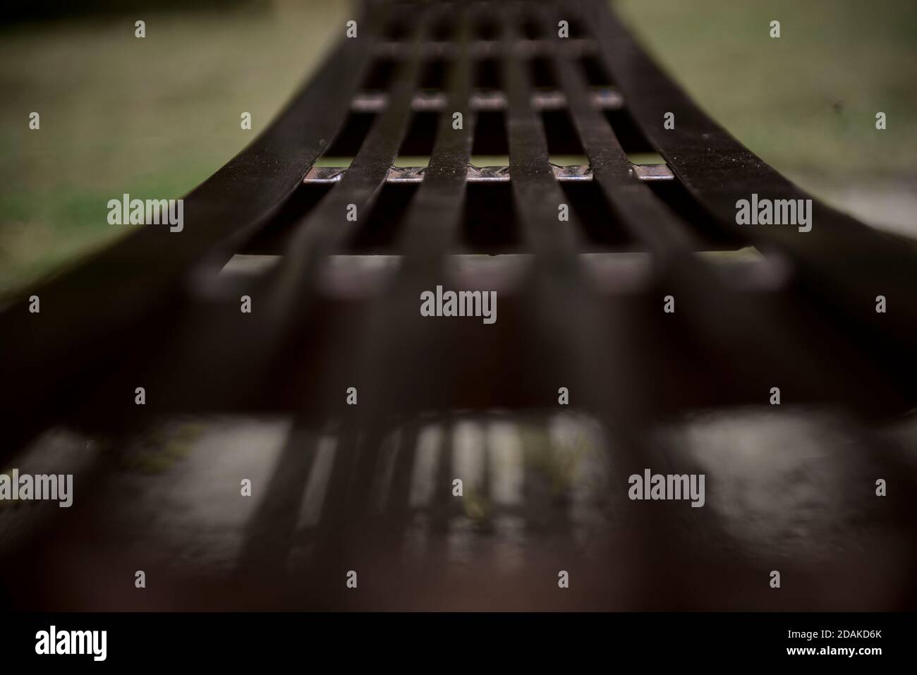 Side view of a black rusty metal park bench Stock Photo - Alamy