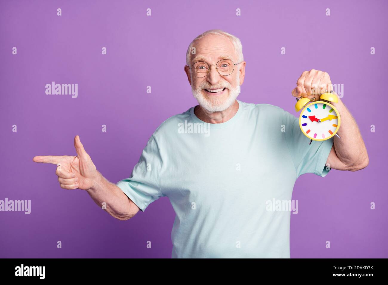 Portrait of smiling old man holding clock index empty space wear blue t ...