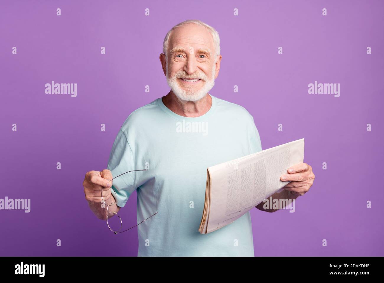 Portrait of funny positive old man reading magazine hold glasses ...