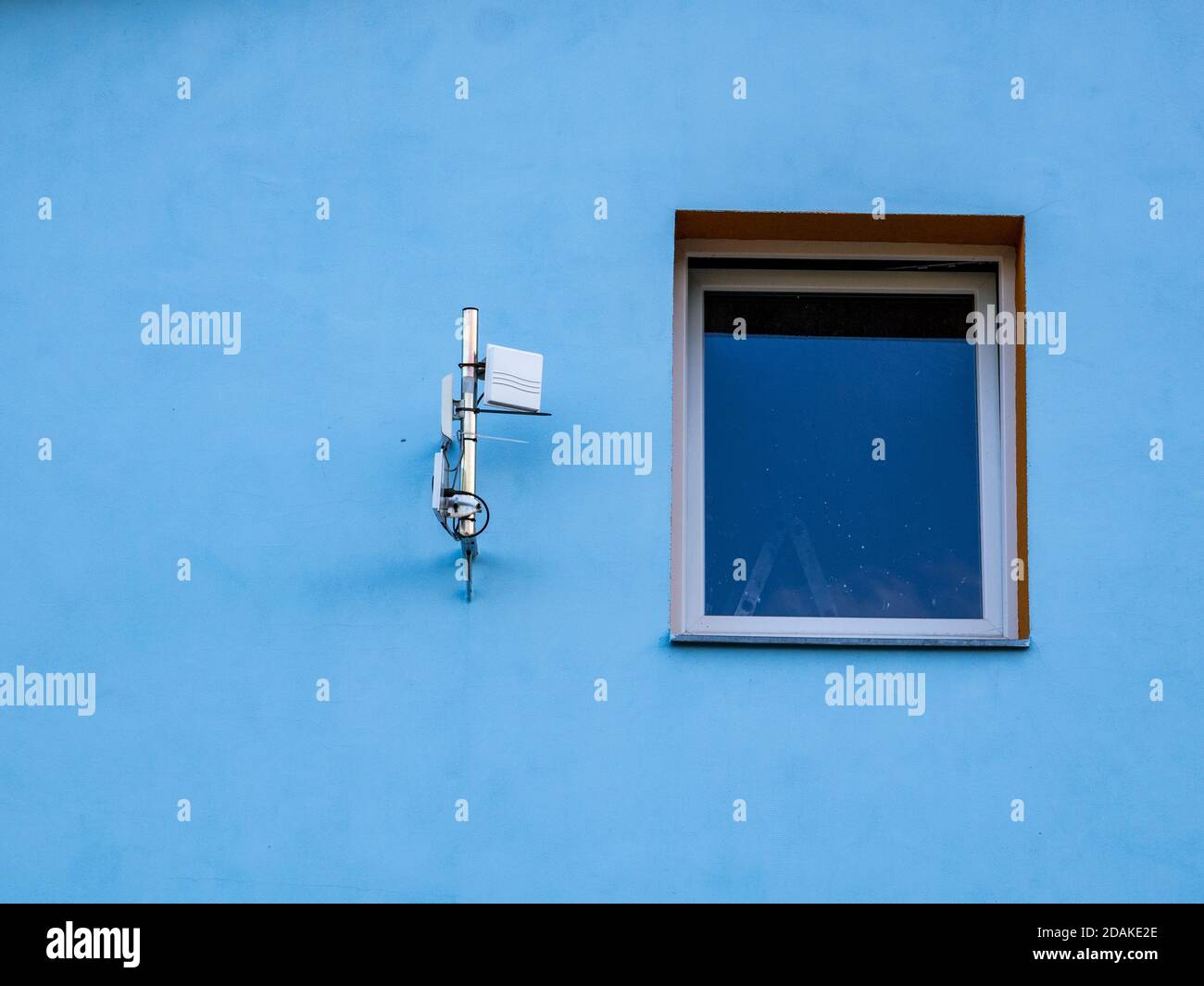 Blue wall with a window and wifi antennas Stock Photo - Alamy