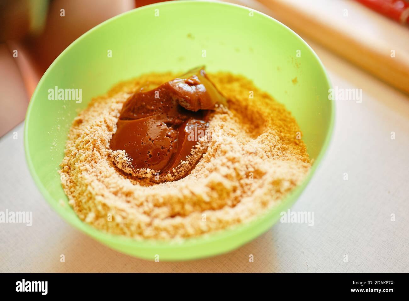Mixing ingredients for pie. Boiled condensed milk with ground cookies ...