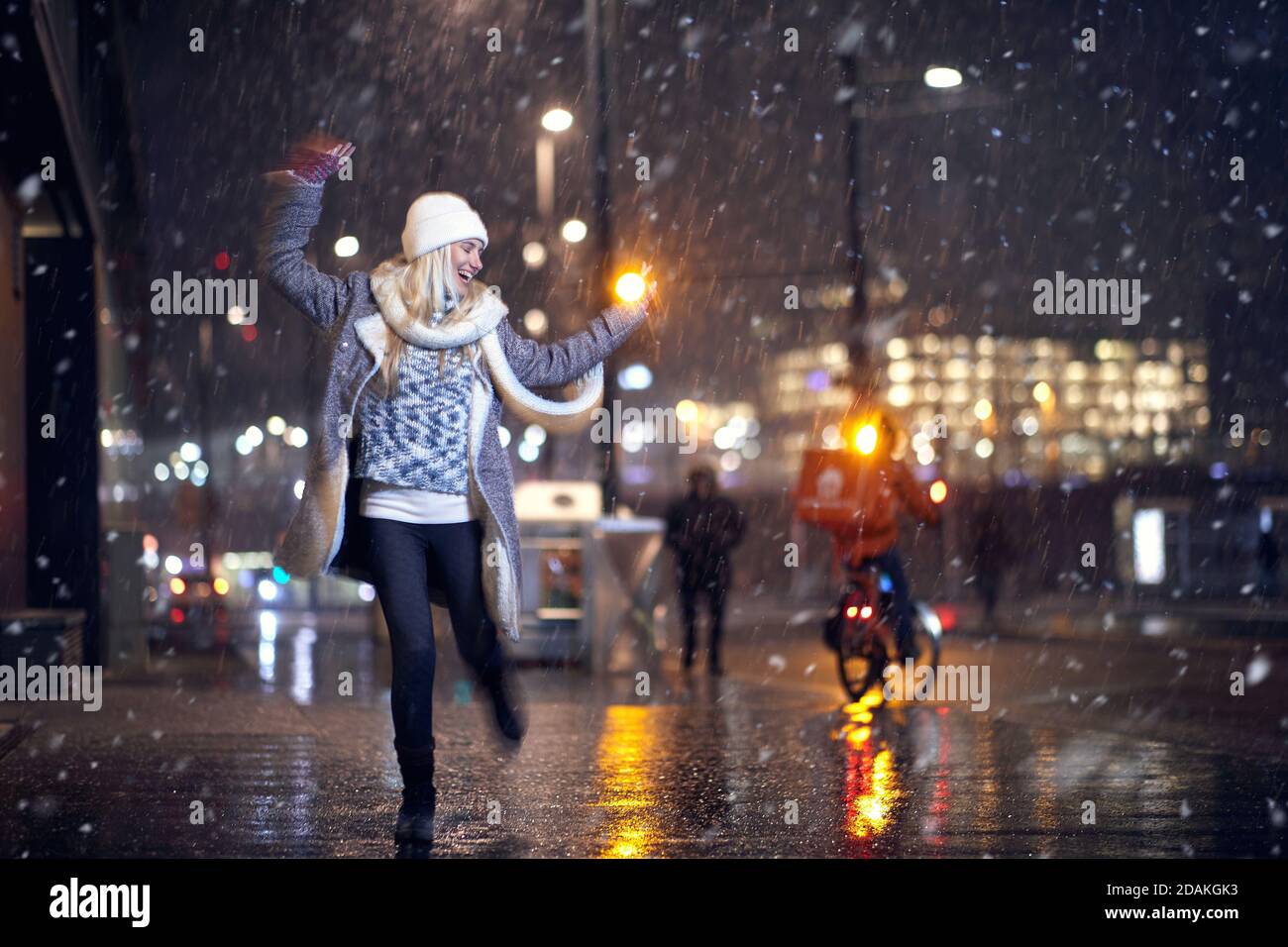 smiling woman dancing outside on a winter night; Winter snow joy ...