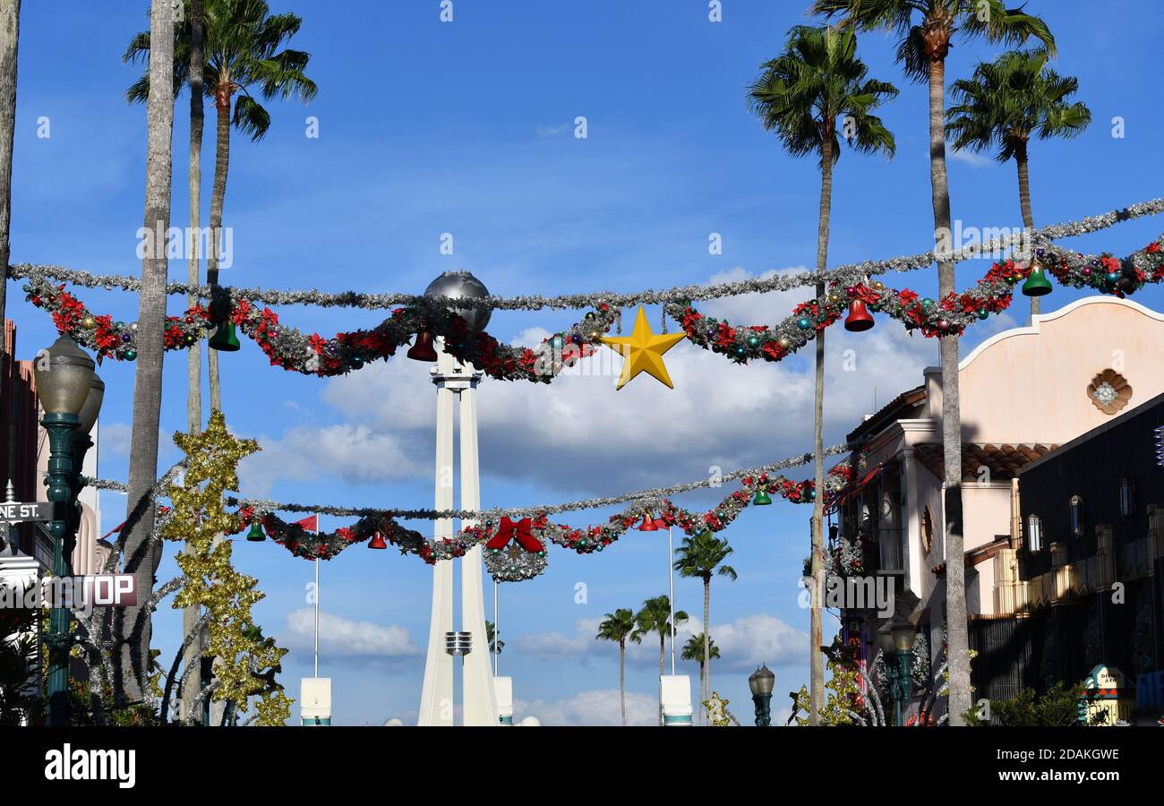 Colorful street decorations and a yellow star with tropical trees under ...