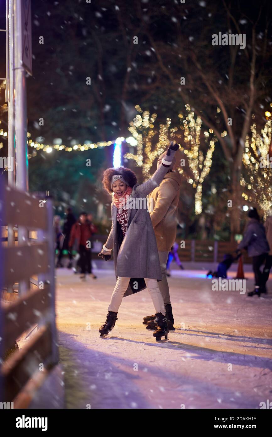A young couple first time on skates having troubles at ice rink on a ...