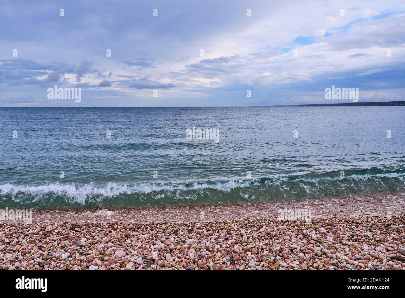 Beautiful seascape. A pebble beach without people with an incoming wave ...