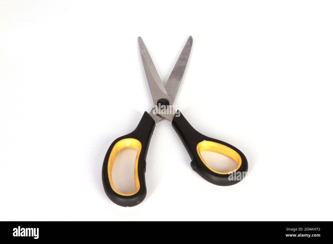Closeup shot of black and yellow scissors isolated on a white ...