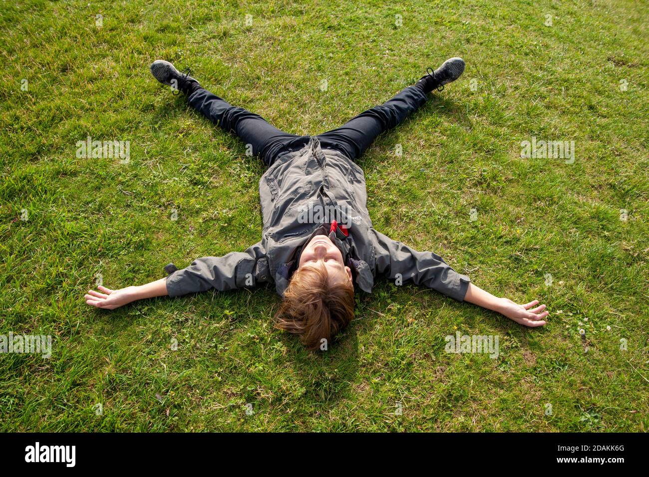 A handsome boy relaxing on a green grass Stock Photo - Alamy