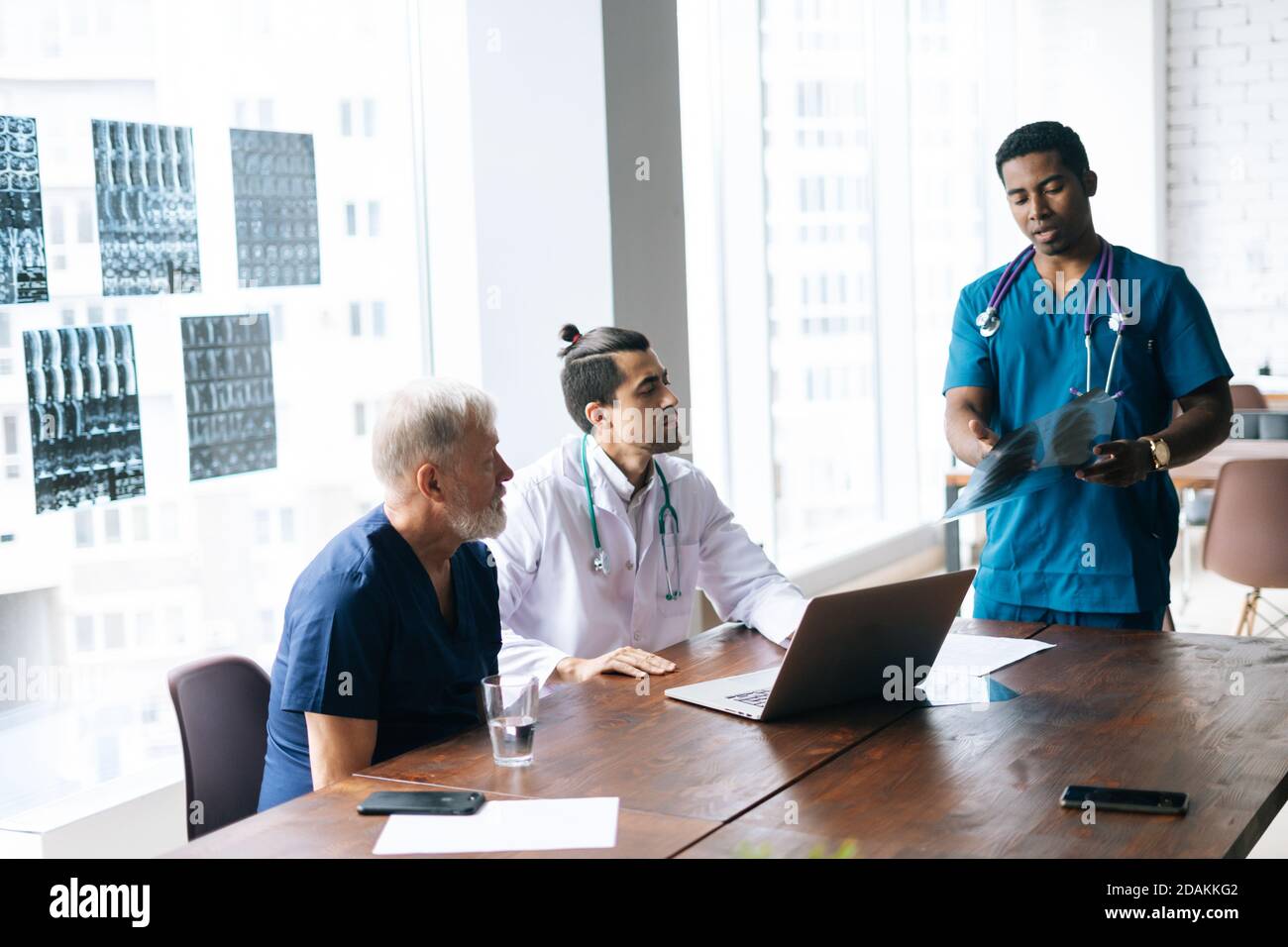 Team of multi-ethnic medical specialists discussing at chest X-ray ...