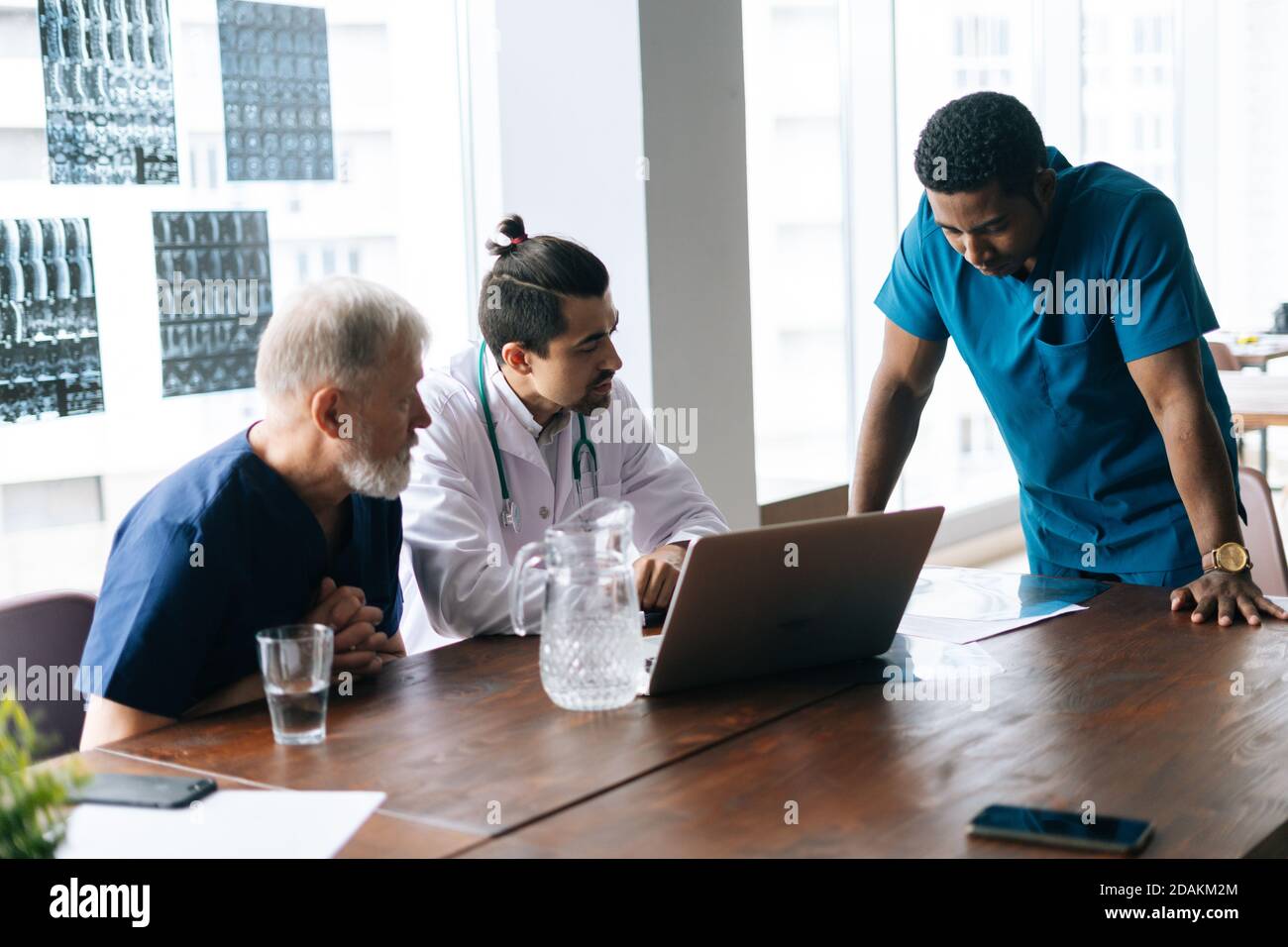 Team of multi-ethnic medical specialists discussing at chest X-ray ...