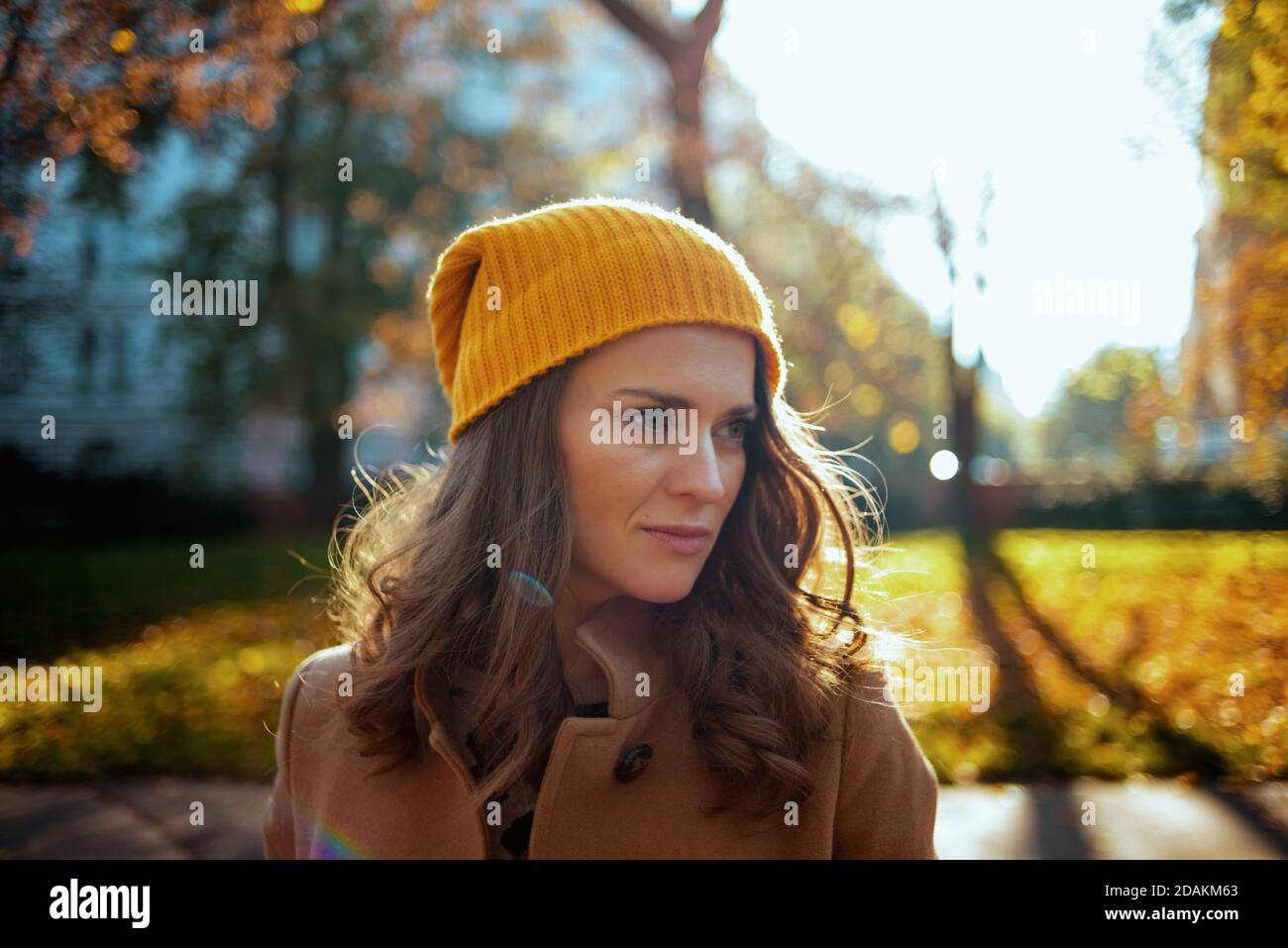 Hello autumn. pensive elegant 40 years old woman in beige coat and ...