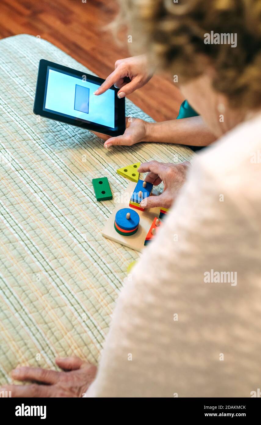 Female doctor showing geometric shapes to elderly patient Stock Photo ...
