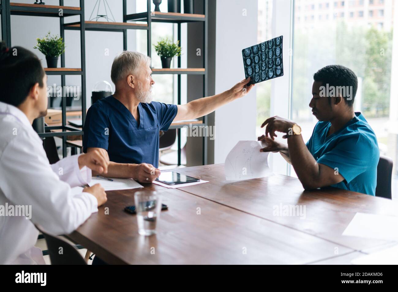 Team of professional doctors discussing together history disease of ...