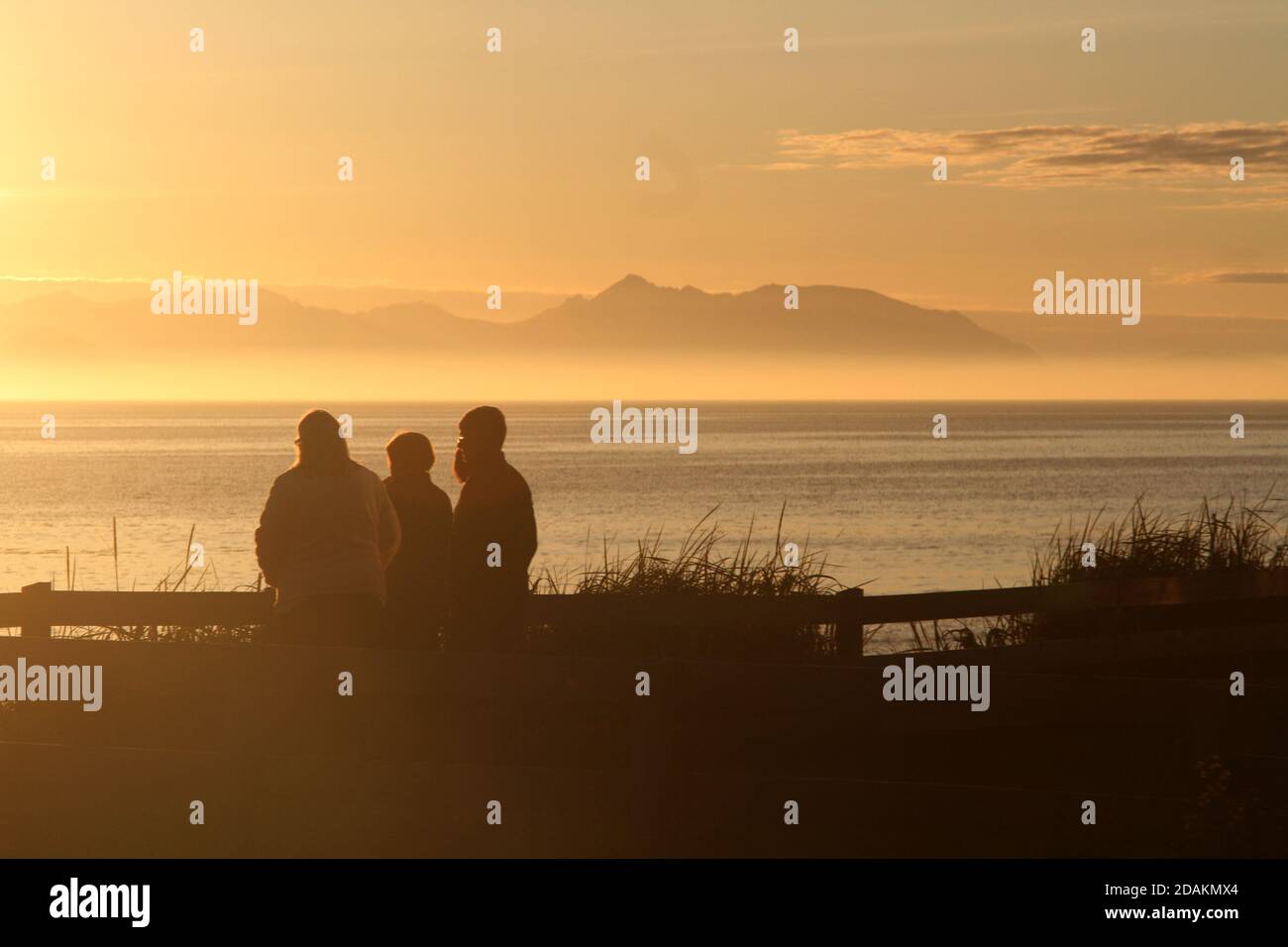 Croy Shore , Ayrshire, Scotland UK. People enjoying sunset over Arran ...