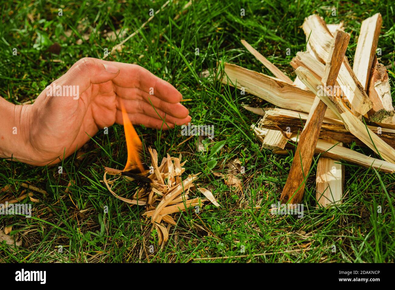 Male camper kindling to start a campfire, bonfire close-up Stock Photo ...