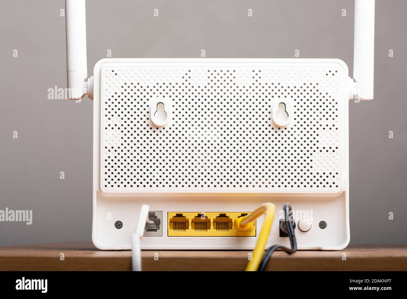 Modern white wireless internet router backside with cables and DSL wire ...