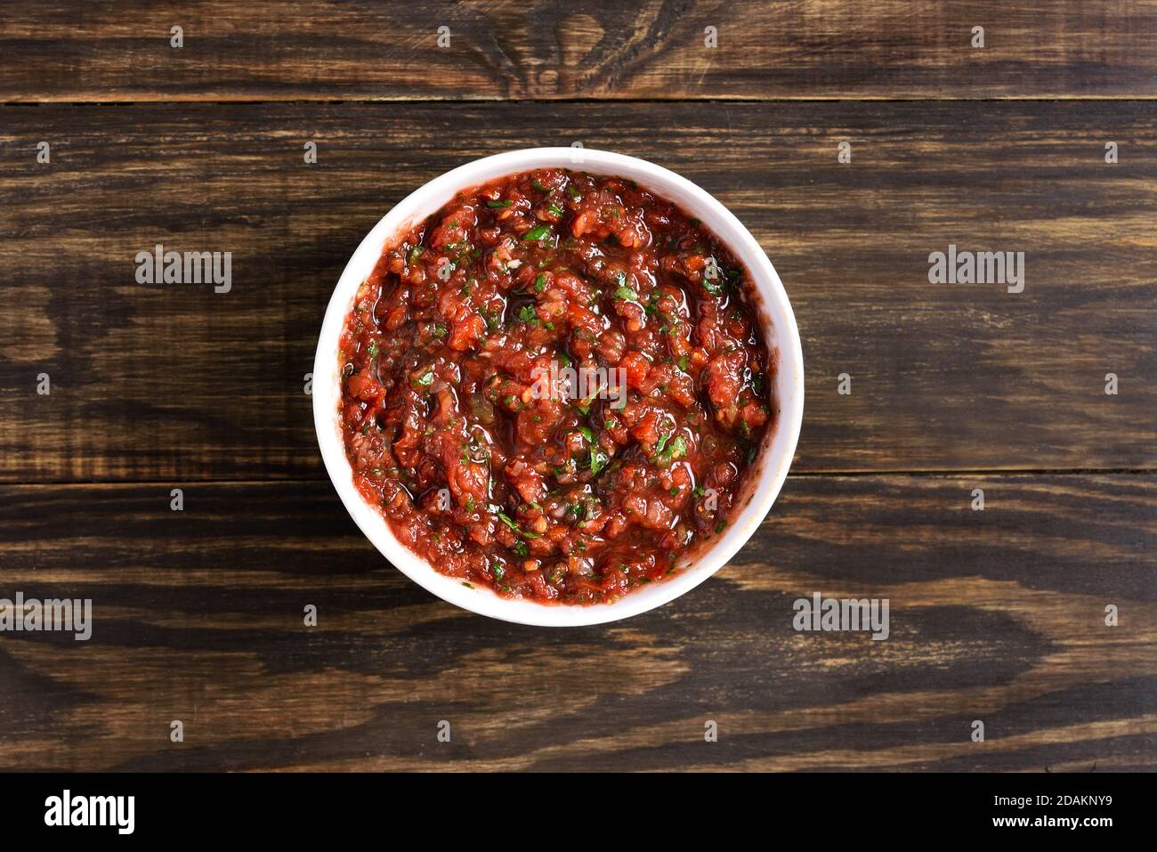 Homemade tomato salsa in bowl over wooden background with free text ...
