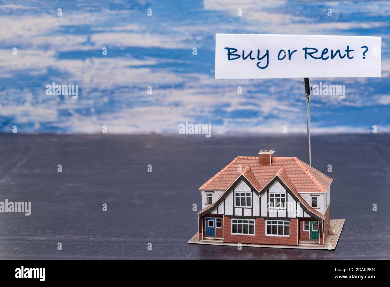 Small model house with a buy or rent sign above it Stock Photo - Alamy