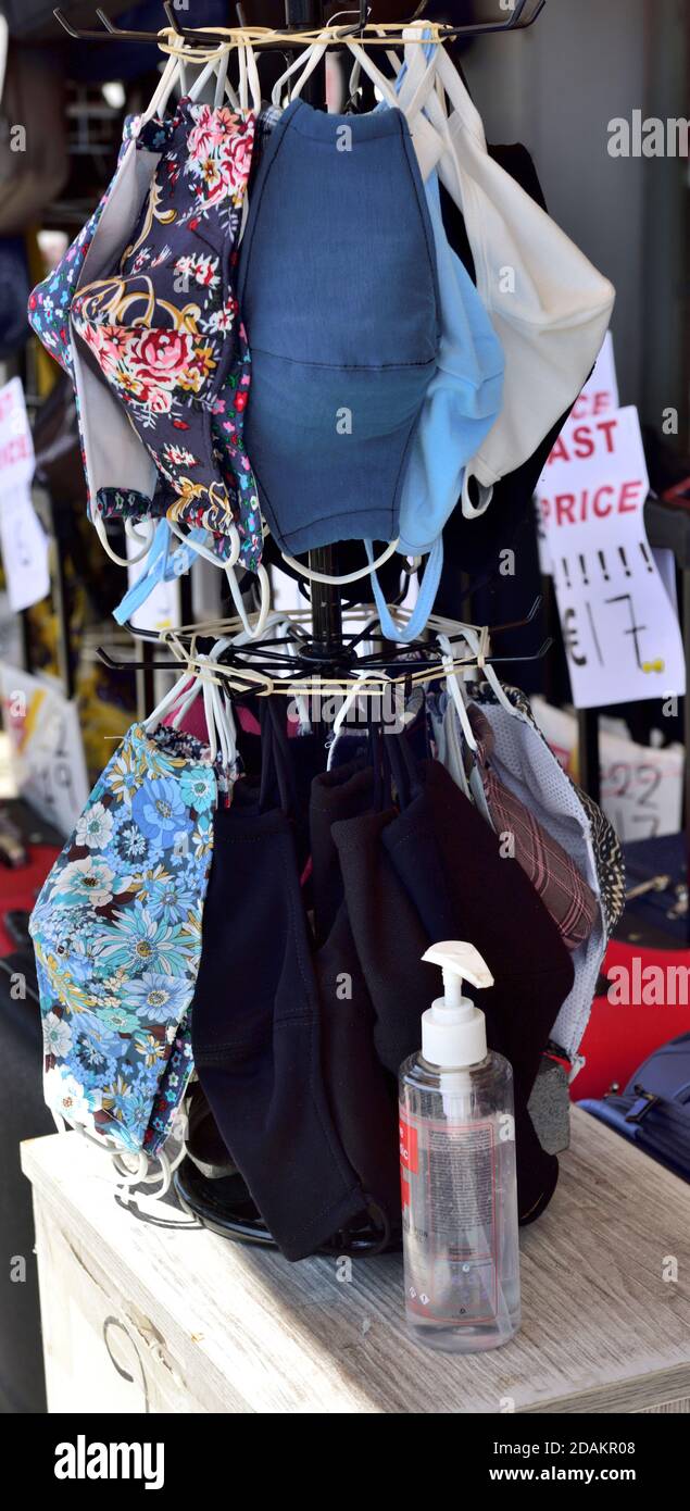 Face masks hanging on display rack in shop with bottle of hand ...