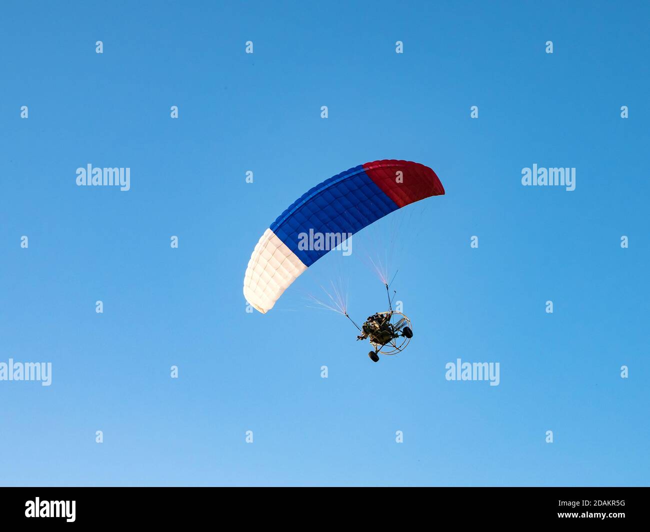 Extreme sports. Powered parachute against the blue sky Stock Photo - Alamy