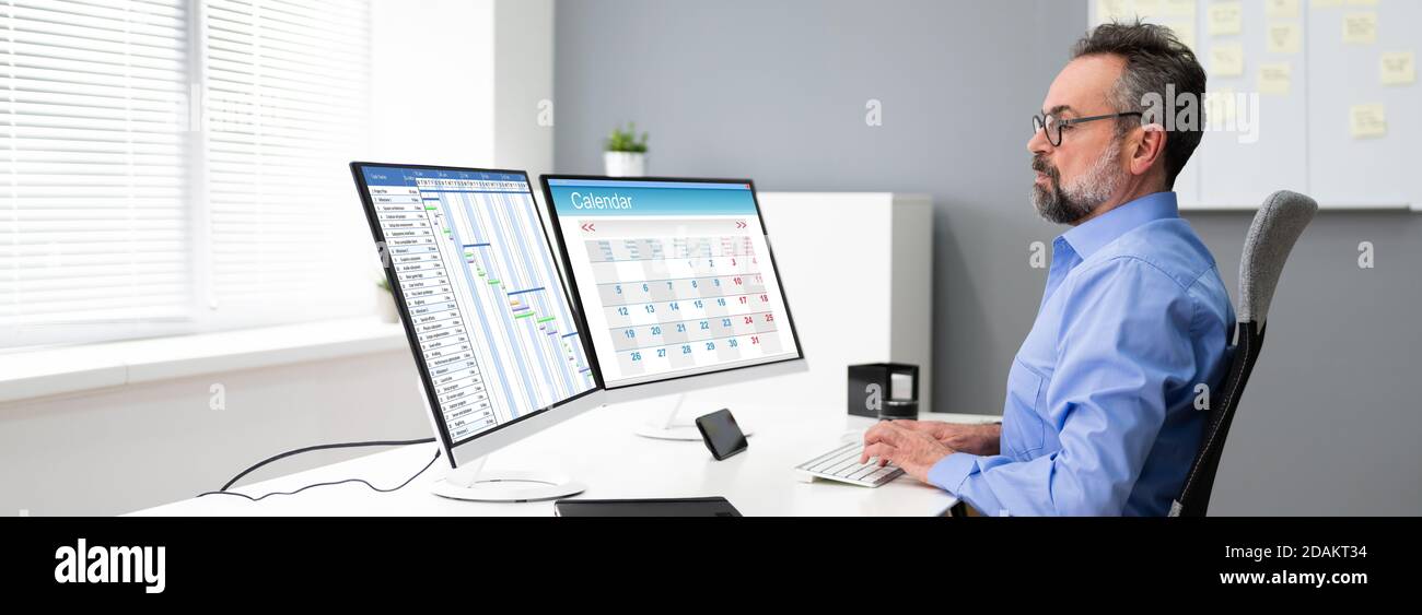 Employee Using Schedule Calendar On Computer Screen Stock Photo - Alamy