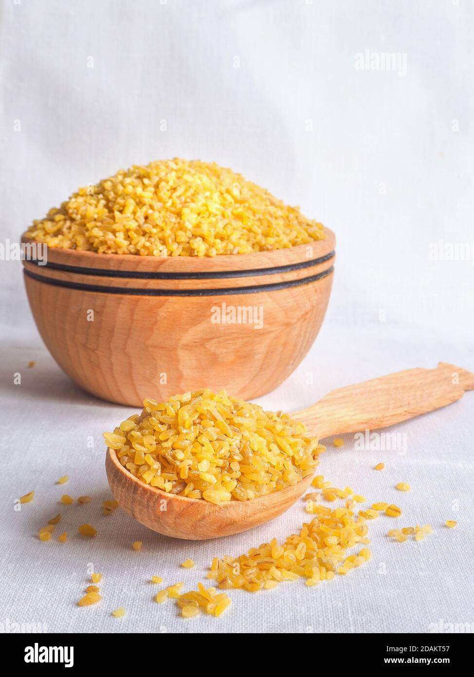 Dry bulgur wheat in wooden bowl. Spilled bulgur Stock Photo - Alamy