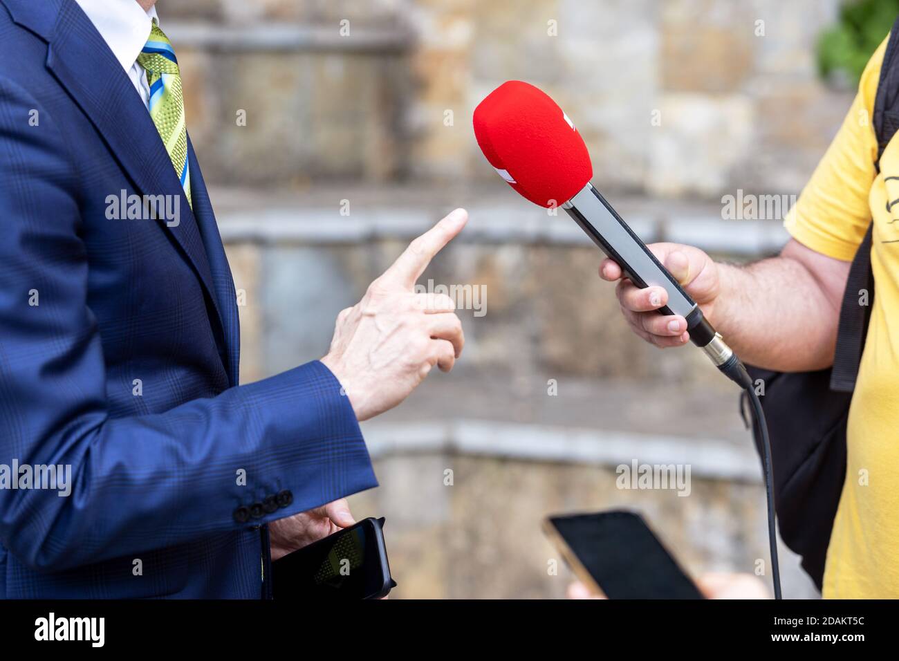 Journalist holding microphone making media interview with politician or business person Stock ...