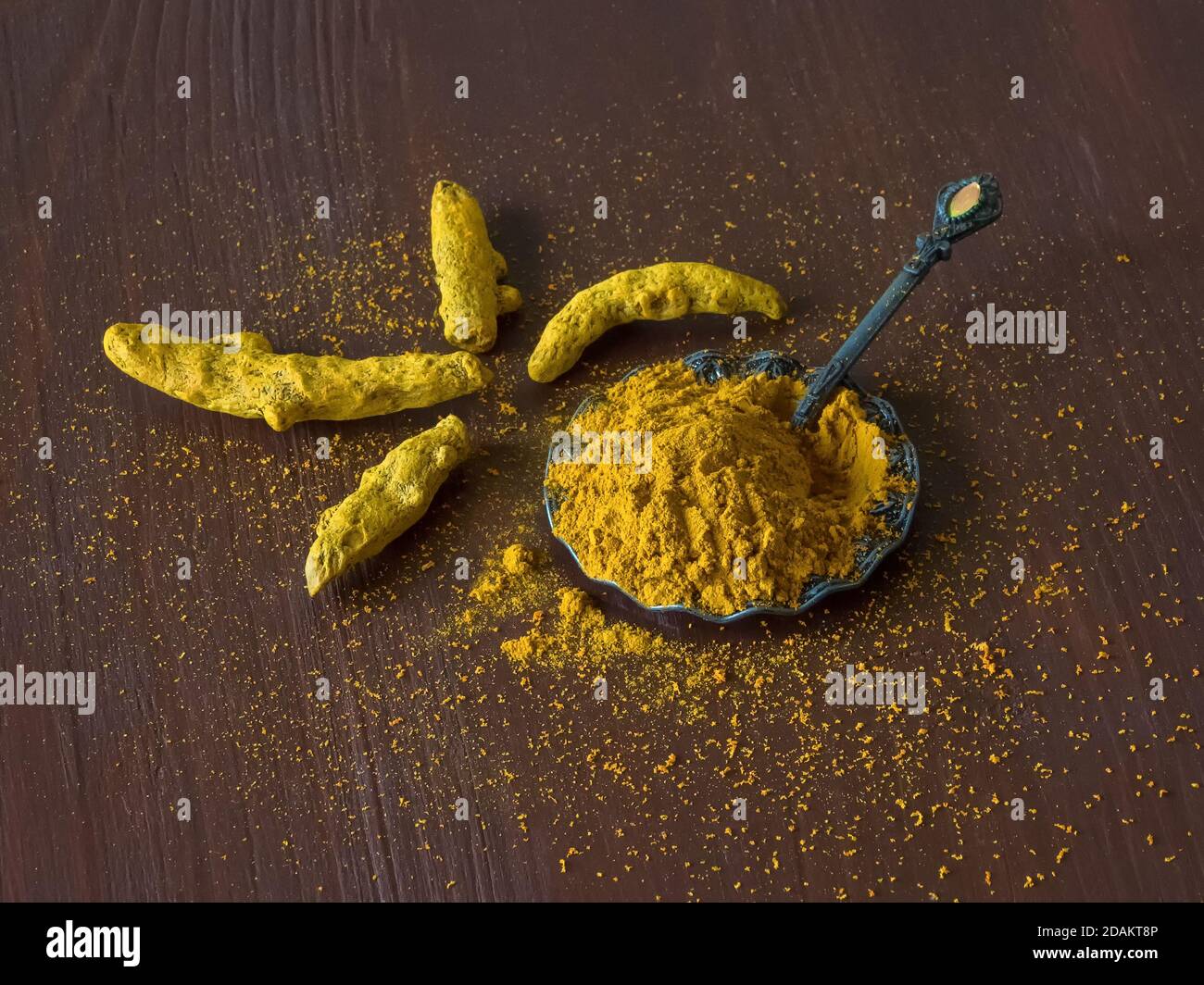 Turmeric powder and roots turmeric on brown table. Ingredients of ...
