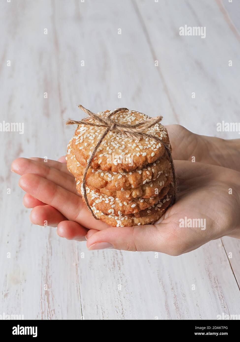 Hands holding a stack of fresh sesame cookies Stock Photo - Alamy