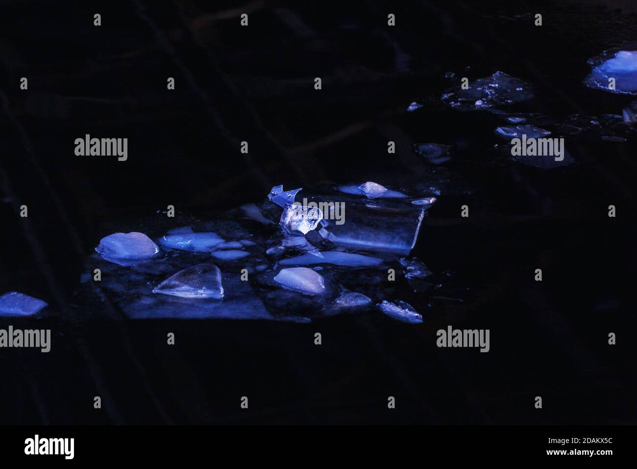 Beautiful real light blue ices in dark water Stock Photo - Alamy