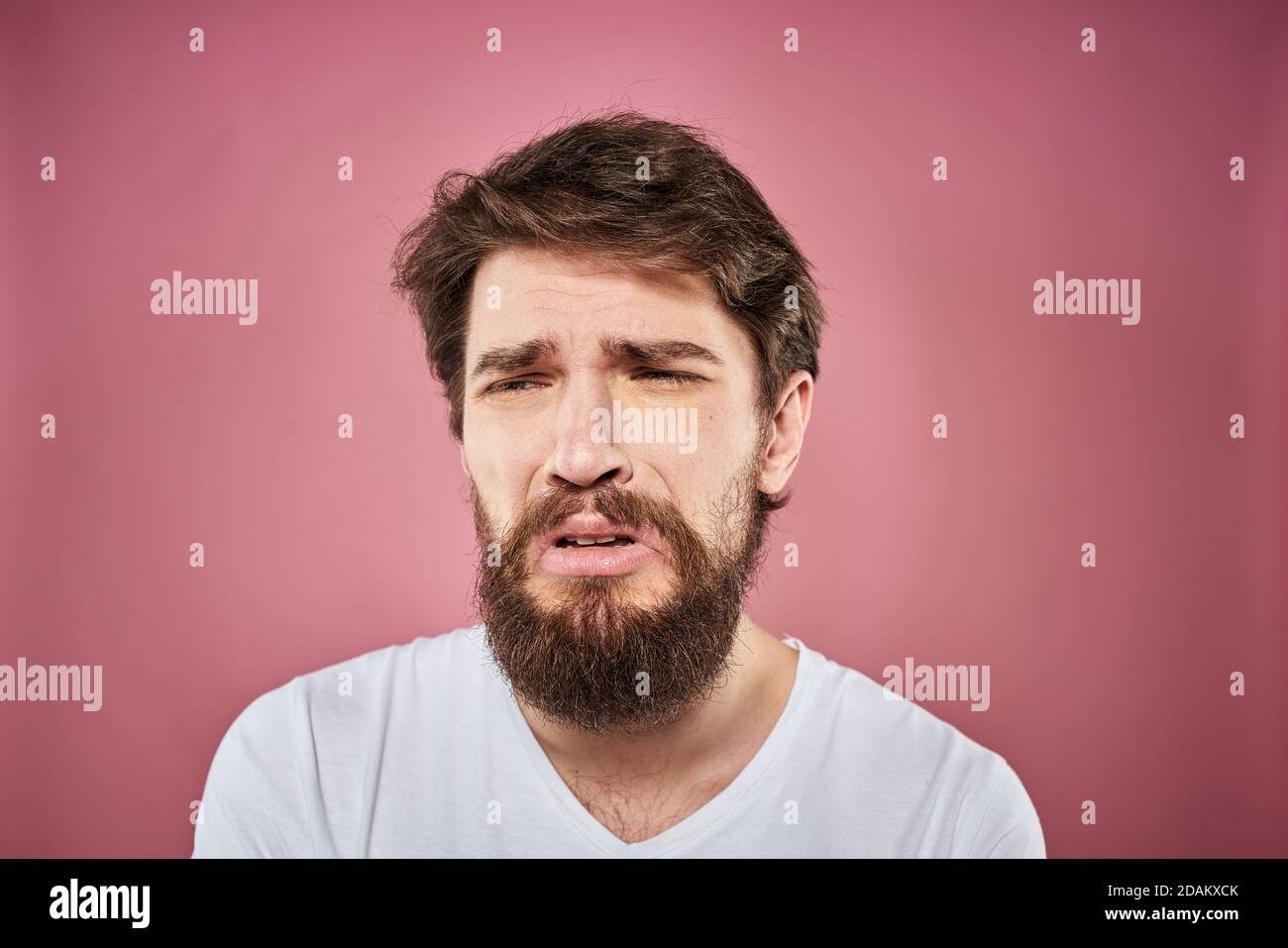 bearded man in white t-shirt emotions displeased facial expression ...