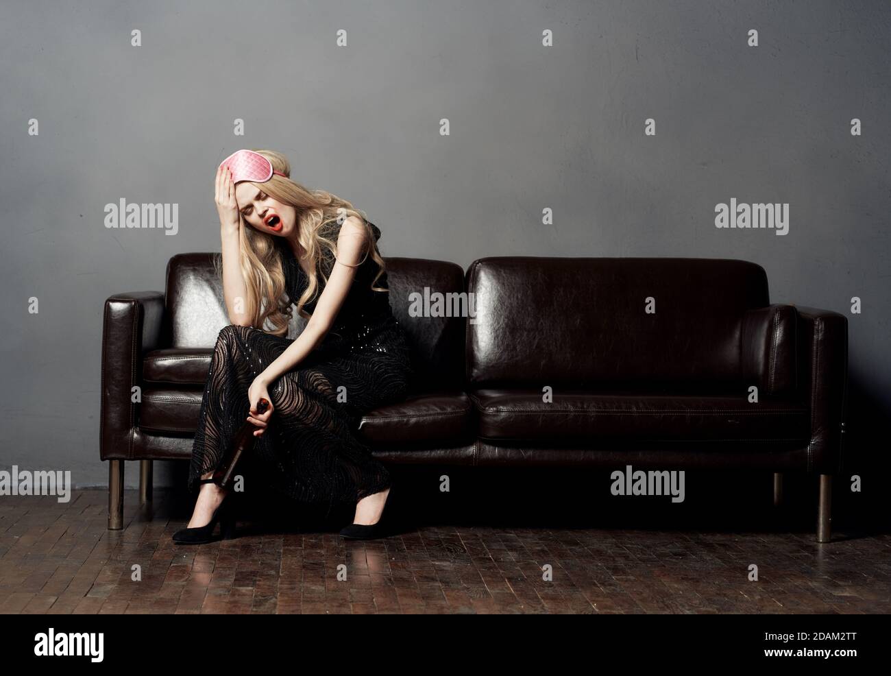 Women on leather sofa bottle of beer alcohol room gray wall Stock Photo ...