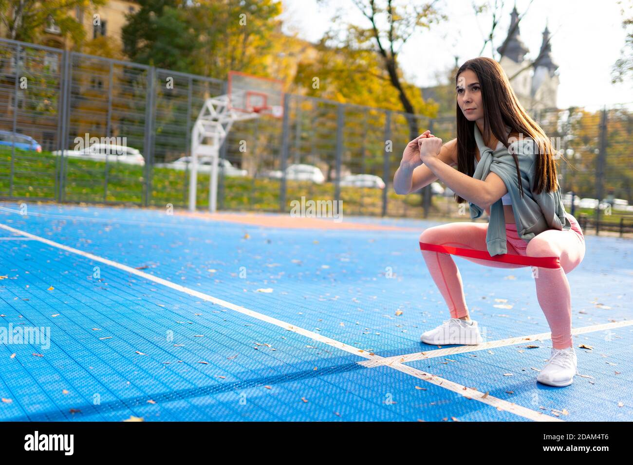 Athletic woman doing squats with resistance bands Stock Photo - Alamy