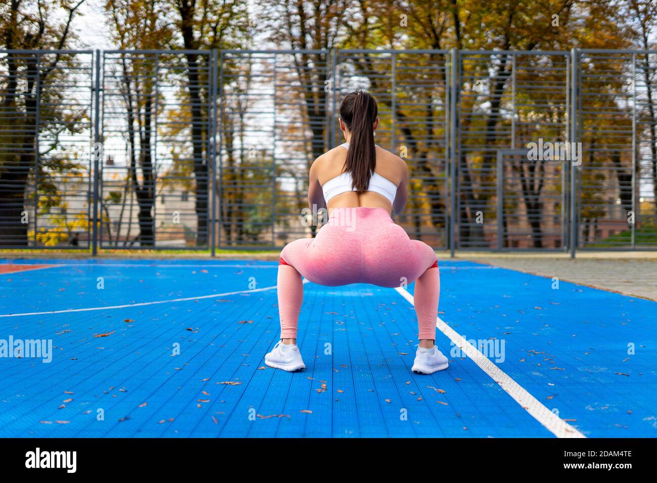 Athletic girl doing squats with resistance bands Stock Photo - Alamy