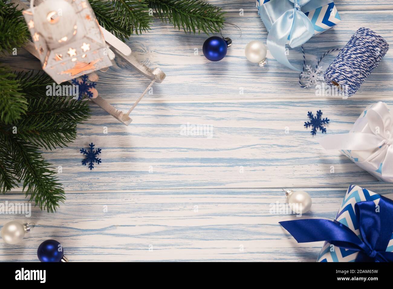 Christmas blue wooden background with fir tree, gift boxes, latern and ...