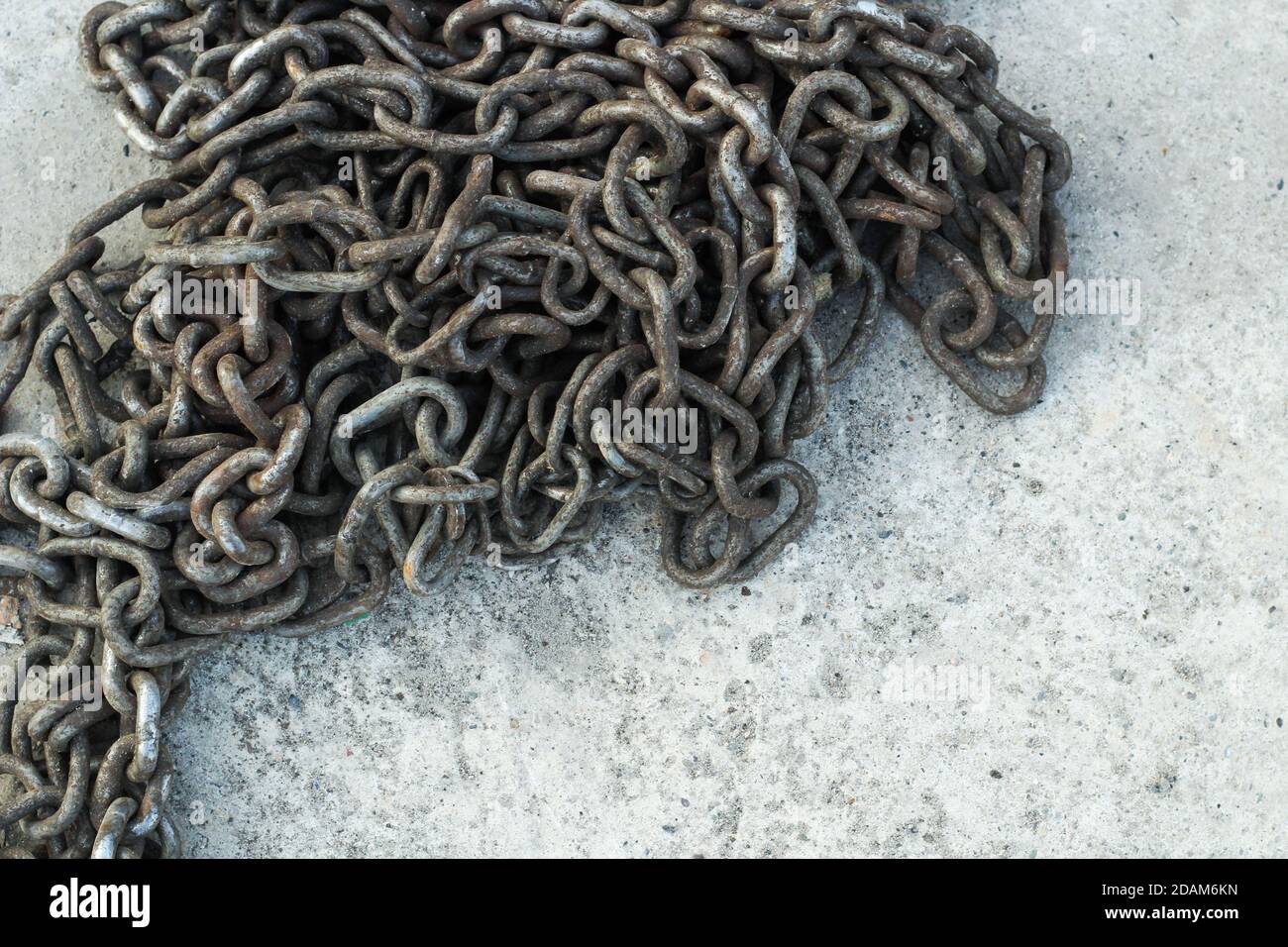 Rusty iron chain on gray concrete Stock Photo - Alamy