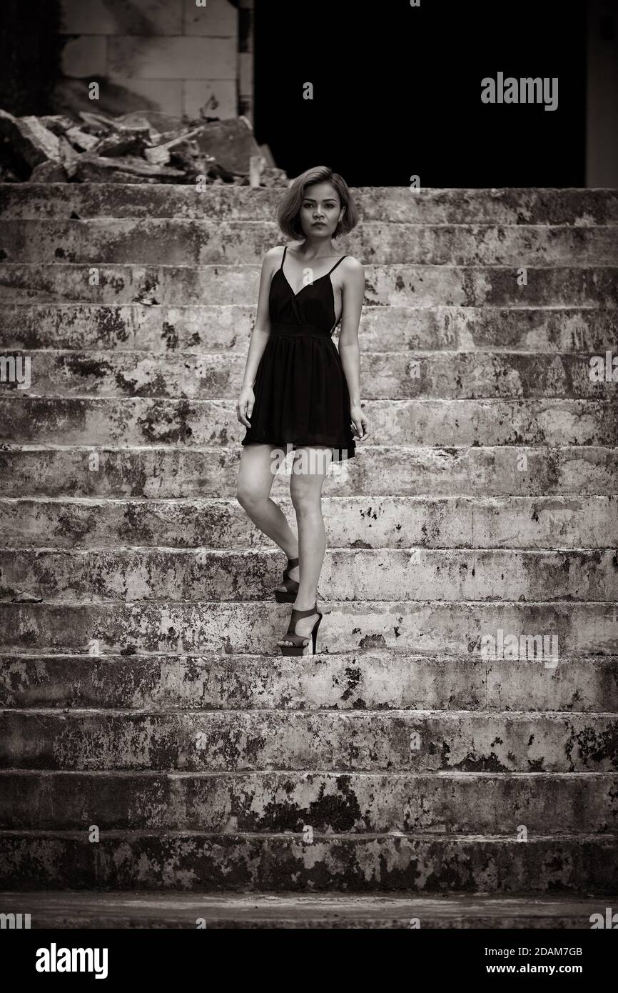 Beautiful girl posing on stairs in the abandoned ruined building. Sepia ...